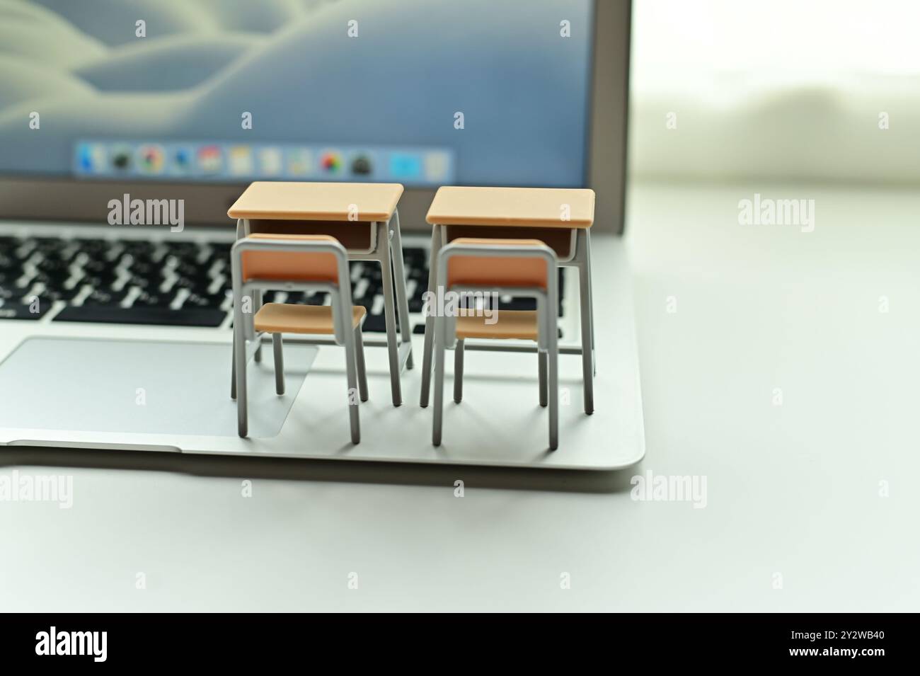 The miniature school desks and chairs placed on a laptop keyboard ...