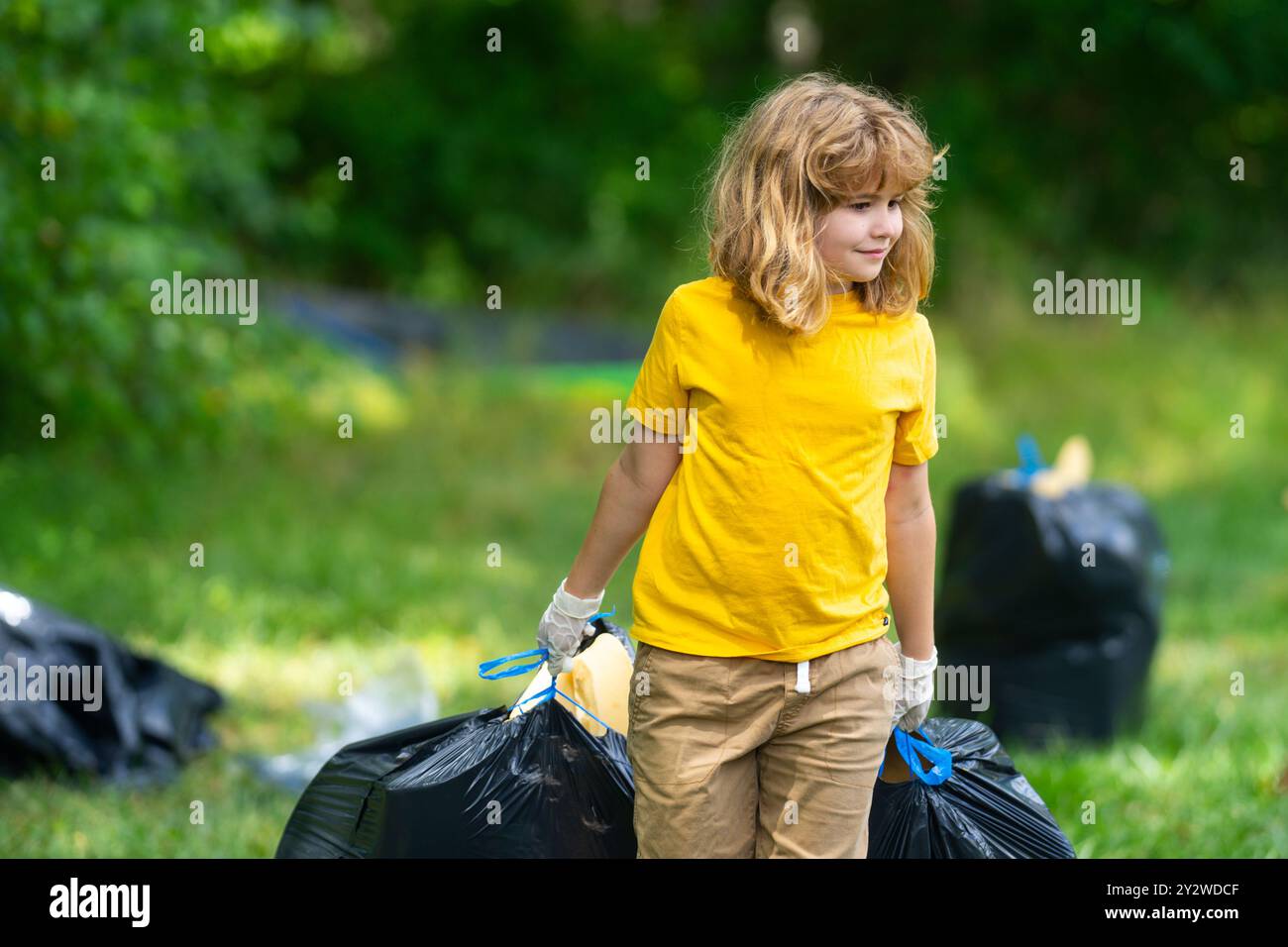 Environment plastic pollution. Volunteer kid collecting trash in the ...