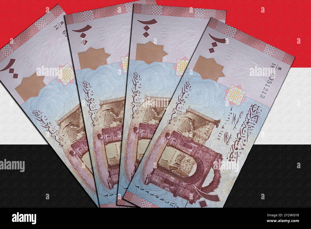 Four Yemeni rial banknotes placed on a Yemeni flag background Stock ...