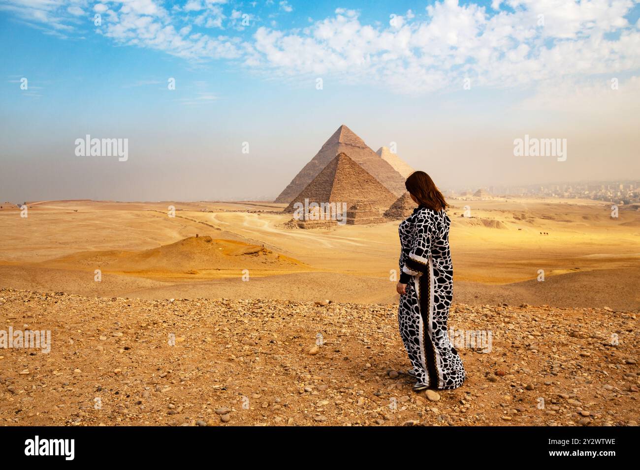 Back view of a woman in a long traditional Muslim dress looking at the ...