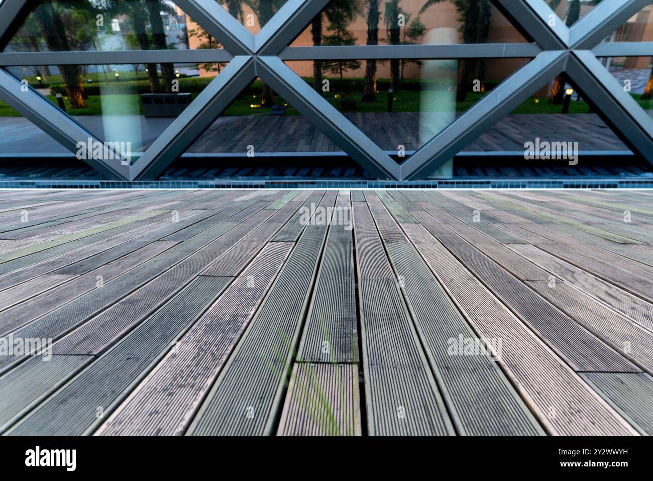 Modern architectural detail featuring a wooden deck and geometric glass ...