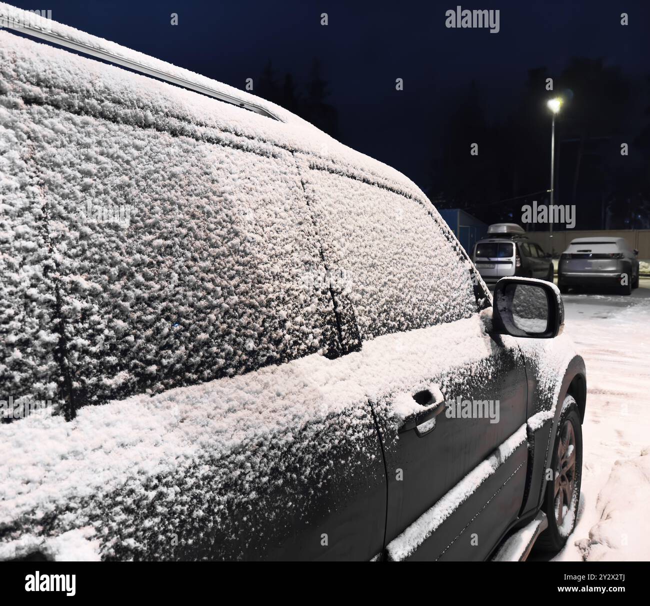 Car covered in snow and frost during a winter storm. White vehicle ...