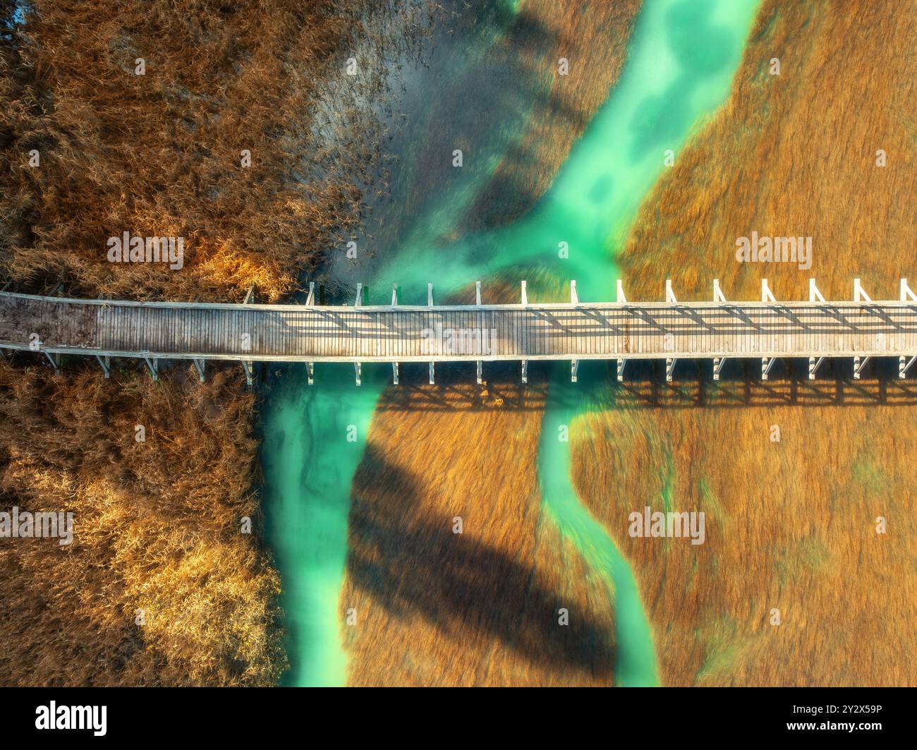 Aerial view of wooden bridge, azure river and orange grass Stock Photo ...