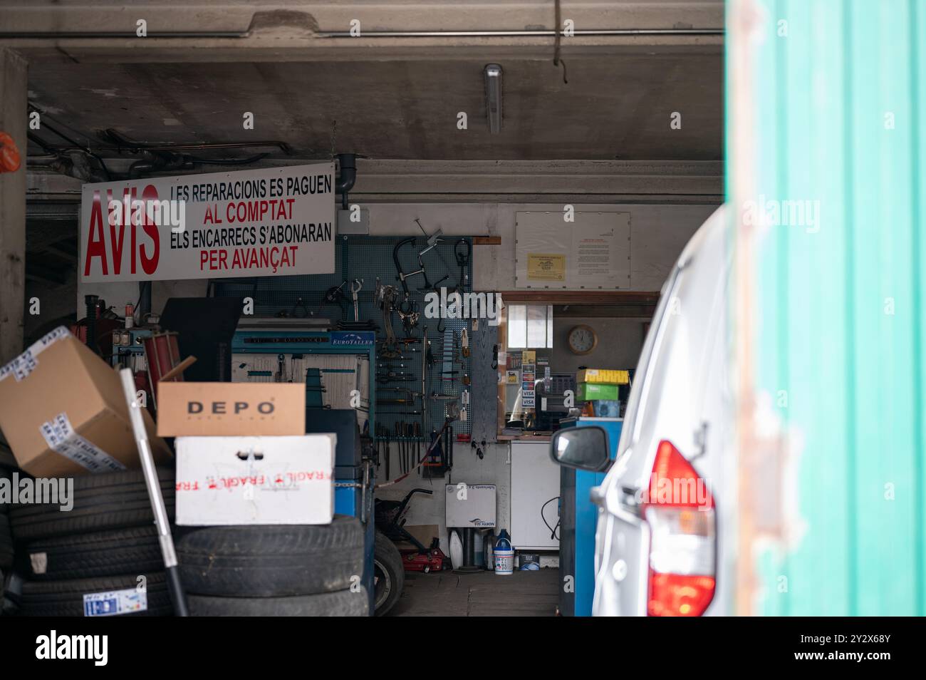 car mechanics workshop, it is a bit messy, with piles of tires and ...
