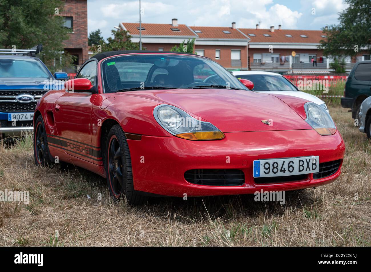 red 1996 first generation Porsche Boxster parked in a grass parking lot ...