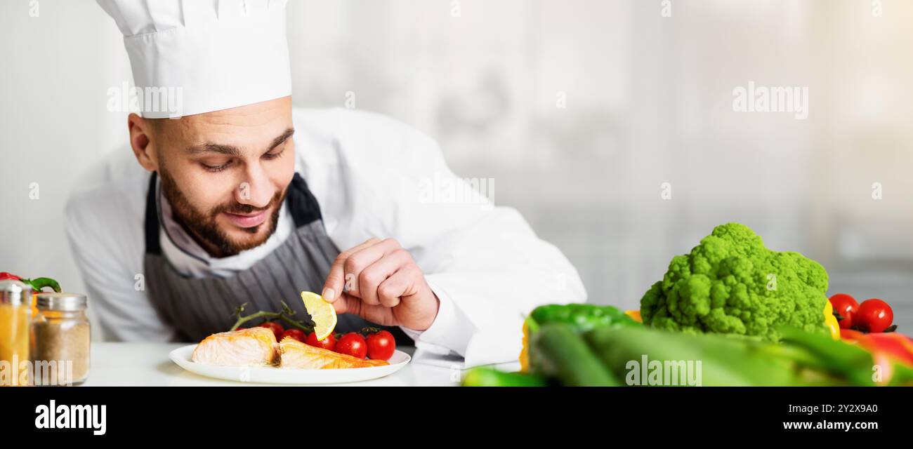 Professional Chef Plating Roasted Salmon Standing In Kitchen Stock ...