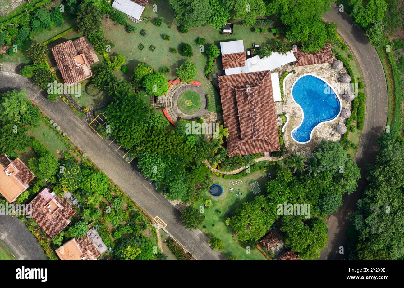 Villa patio with blue pool and green grass above top drone view Stock ...