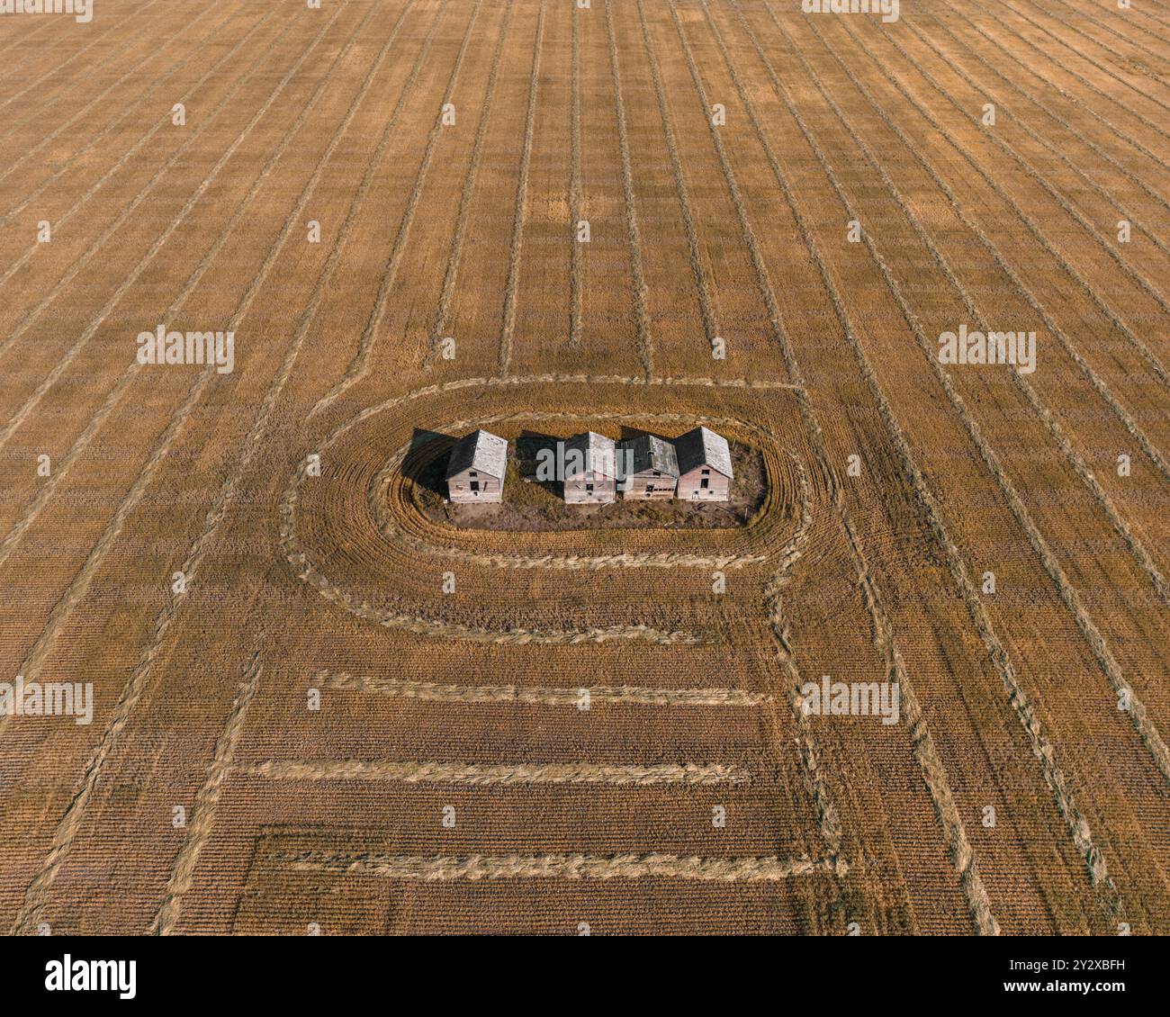 An aerial view of barns in the middle of a harvested field with ...