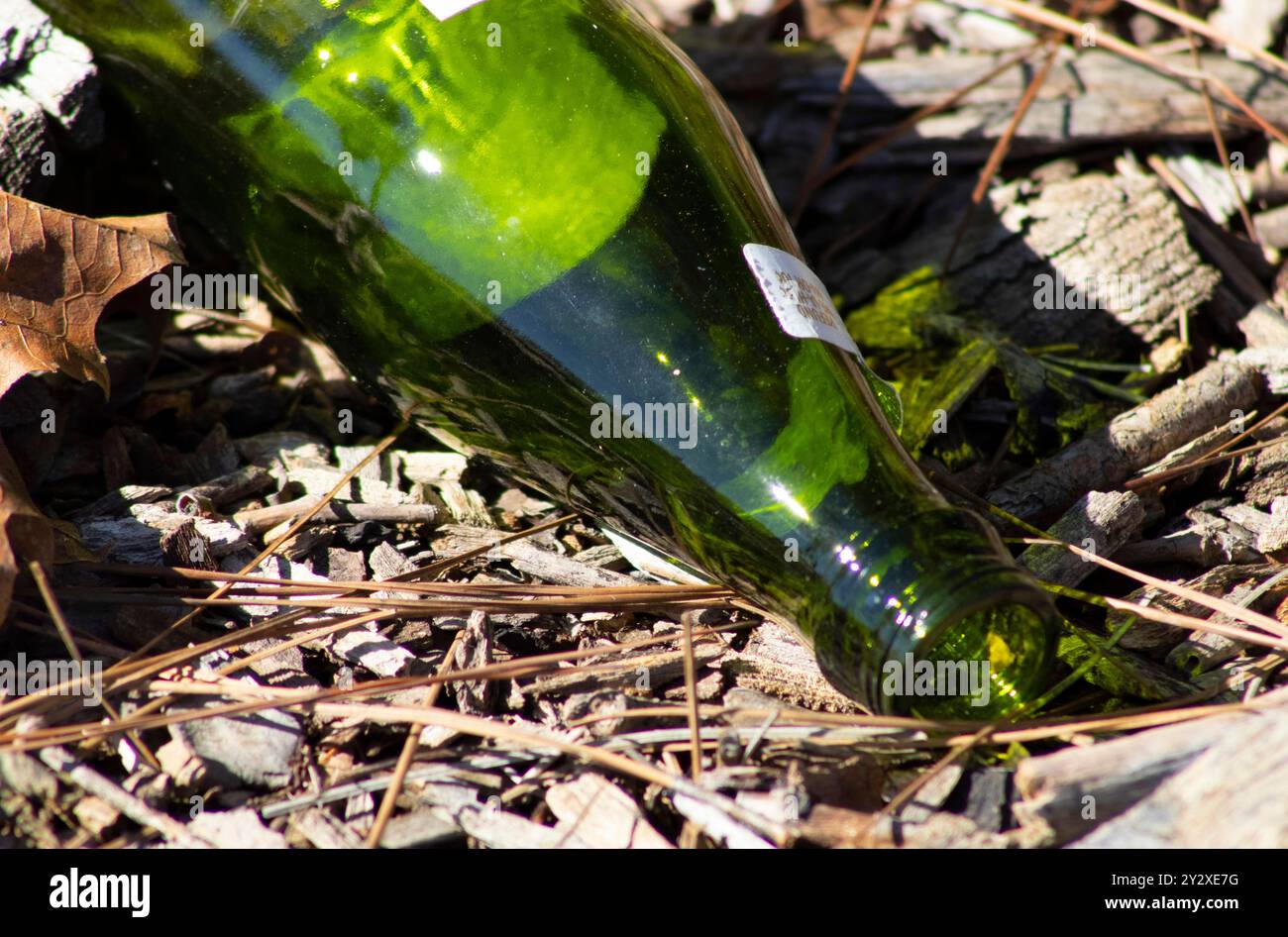 green glass bottle transparent left on ground litter Stock Photo - Alamy