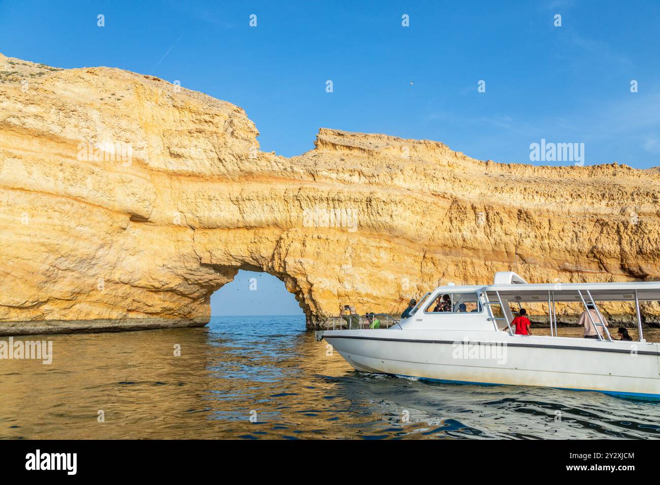Qantab natural arch passage in the rock and boat full of tourists ...