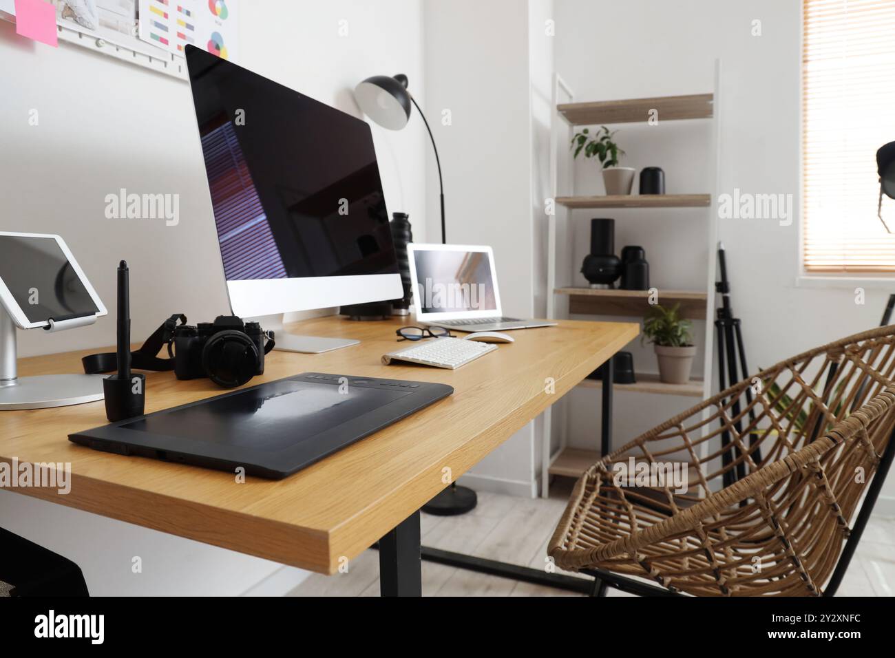 Table with modern computer, photo camera and gadgets in office ...