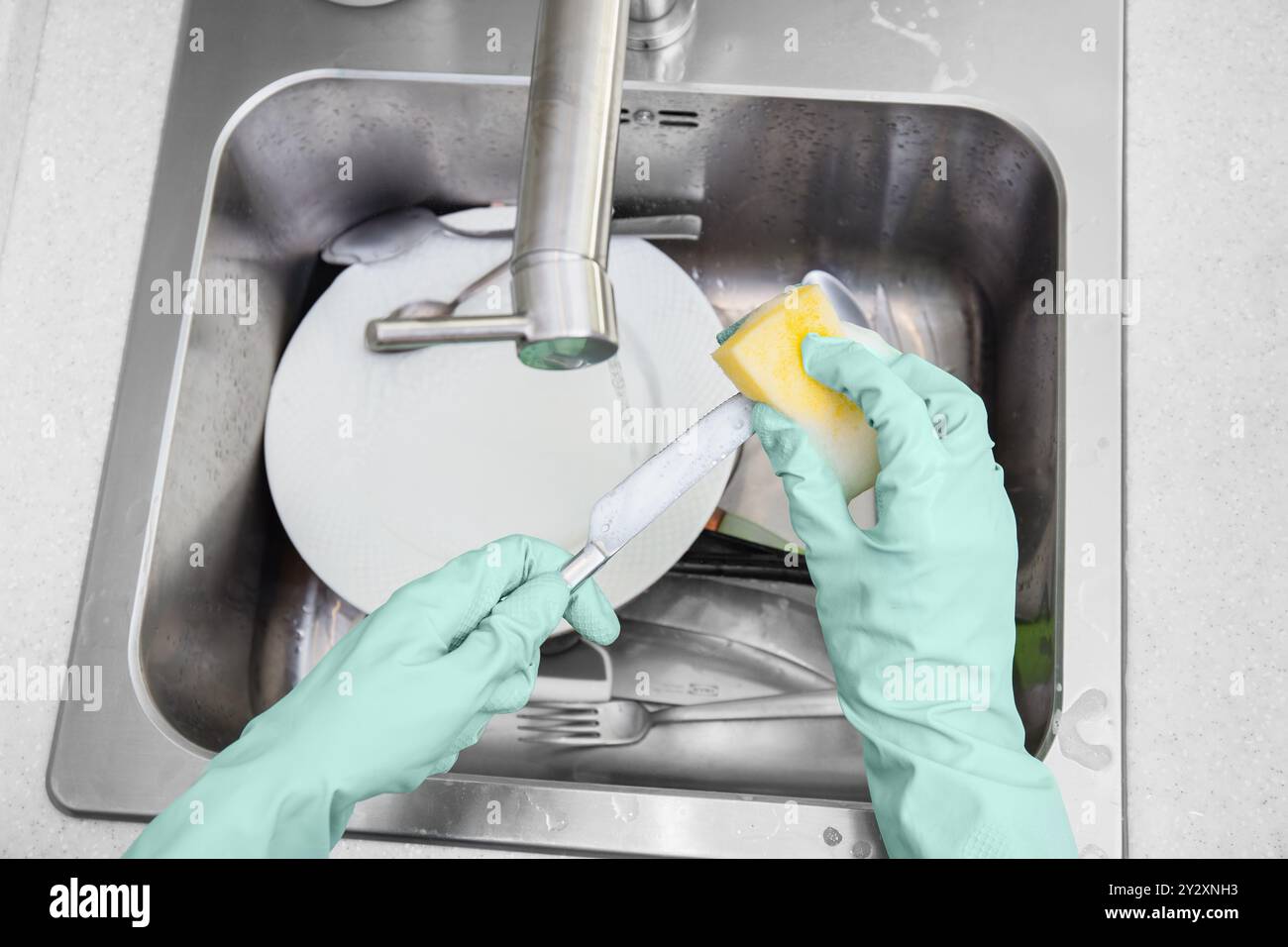 Cleaning service scrubbing knife with sponge while wearing gloves to ...