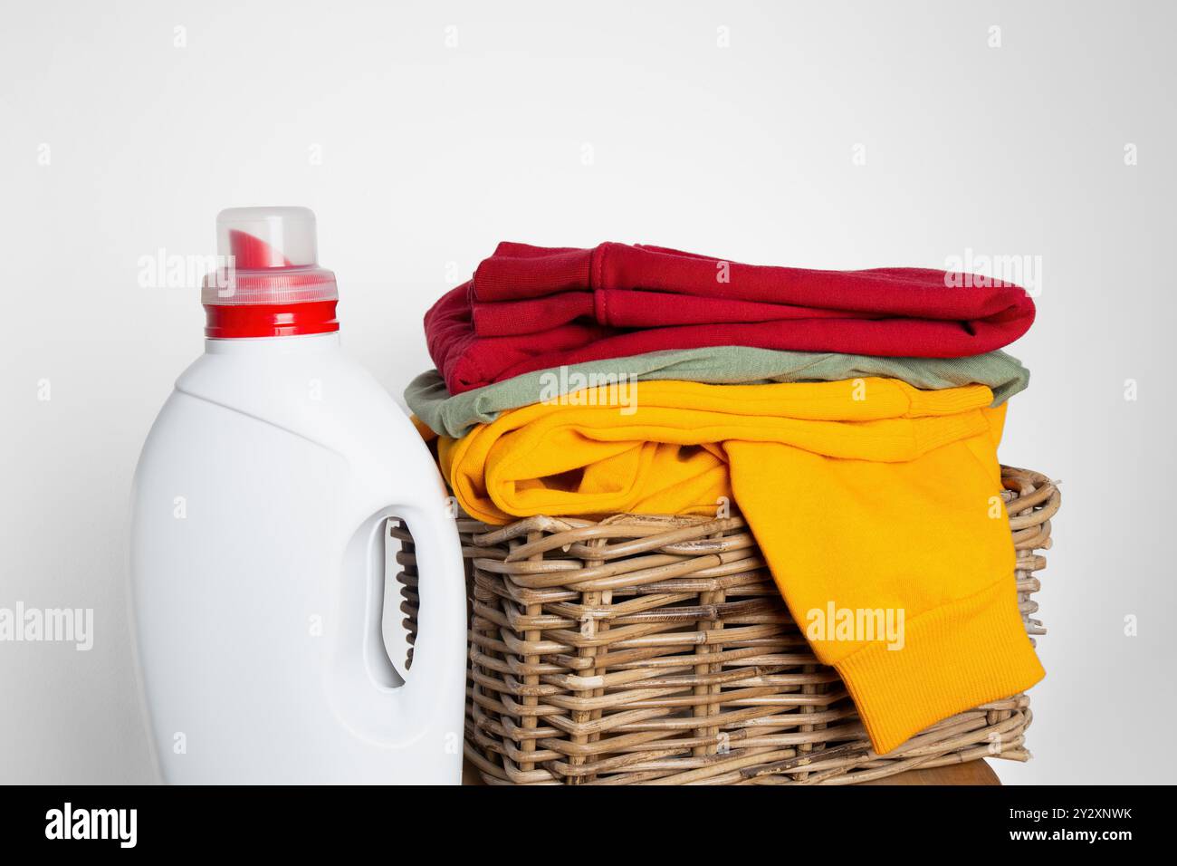 Wicker basket filled with vibrant, neatly folded clothes next to a ...