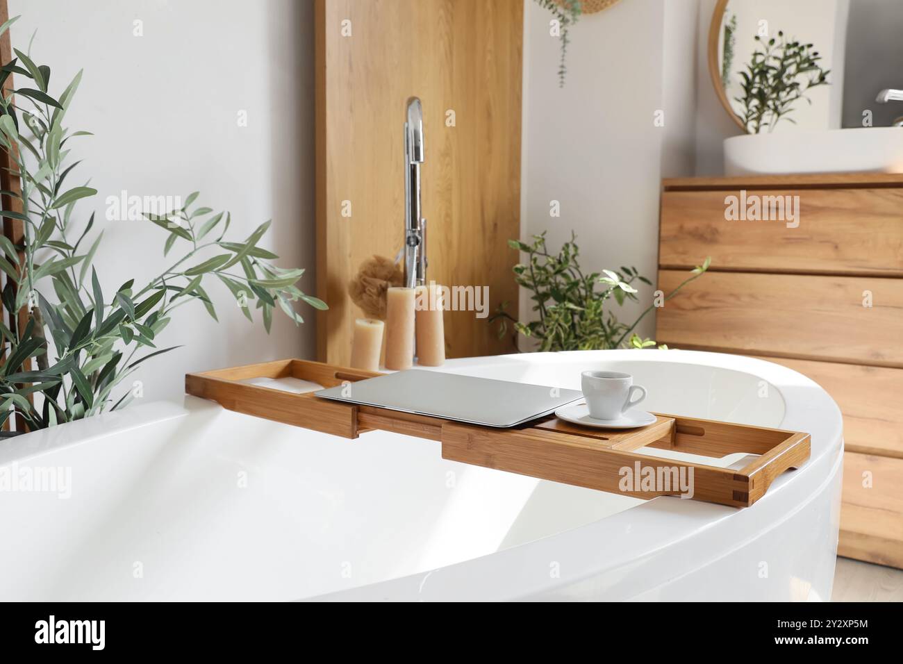 Interior of stylish bathroom with bathtub, board, laptop and ...