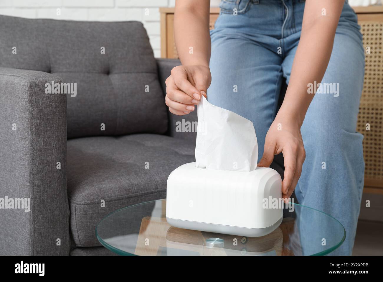 Woman taking tissue from ceramic holder on coffee table at home Stock ...