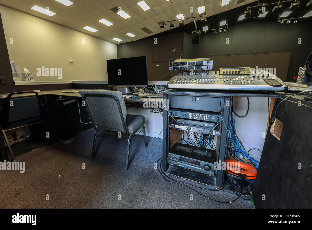 An empty sound control room with a mixing console and various audio ...