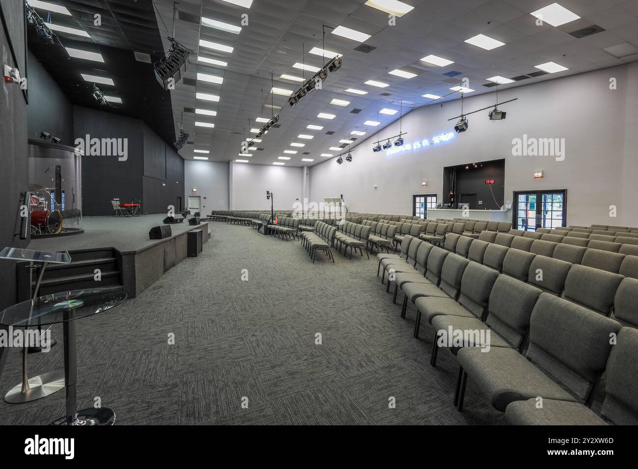 An empty modern church auditorium with rows of seats and stage setup ...