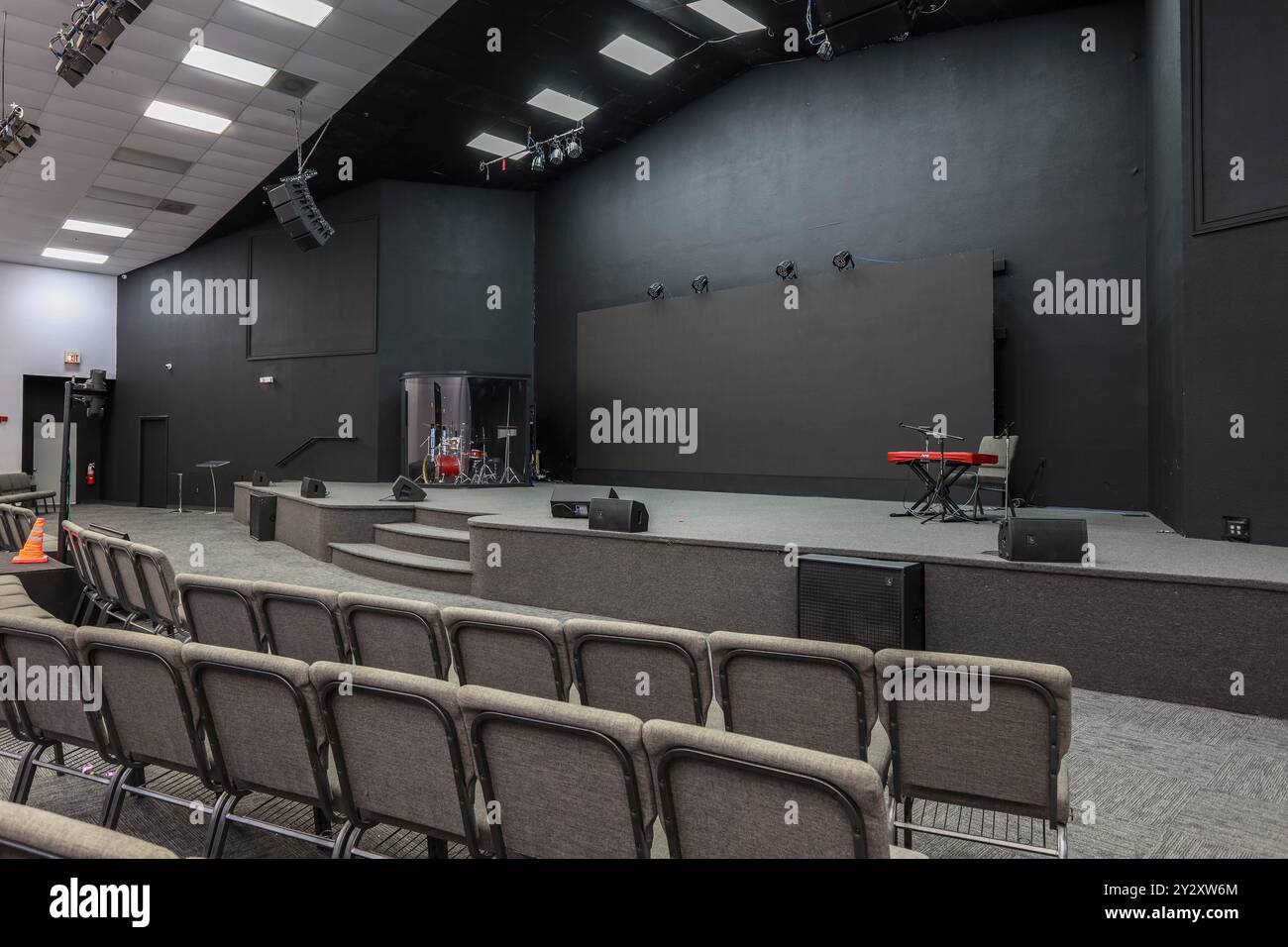An empty modern auditorium with a stage, musical instruments, and rows ...