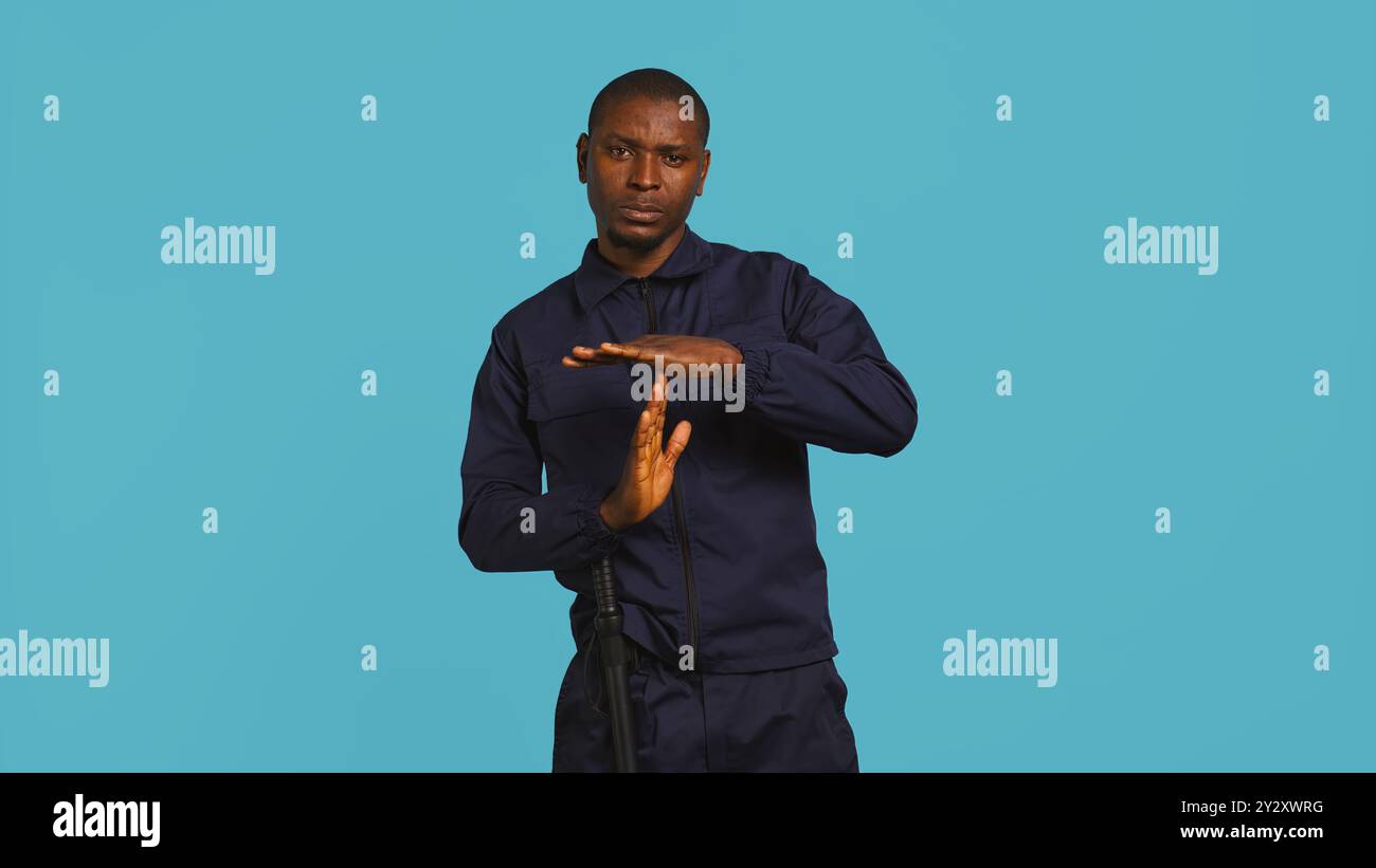 Security guard doing time out sign gesturing, being tasked with ceasing ...