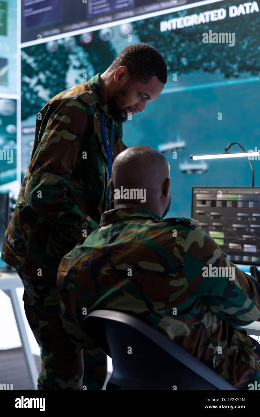 Military staff in a modern operations hub handling critical information ...