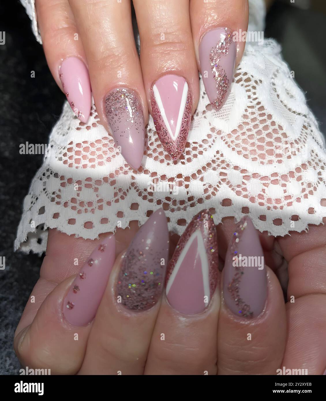 Elegant finger nail designs are seen on a model's hands in this ...
