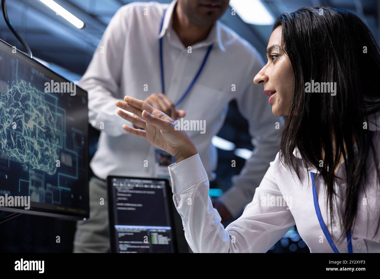Coworkers using AI tech to fix errors in server farm providing storage. IT staff members in data ...