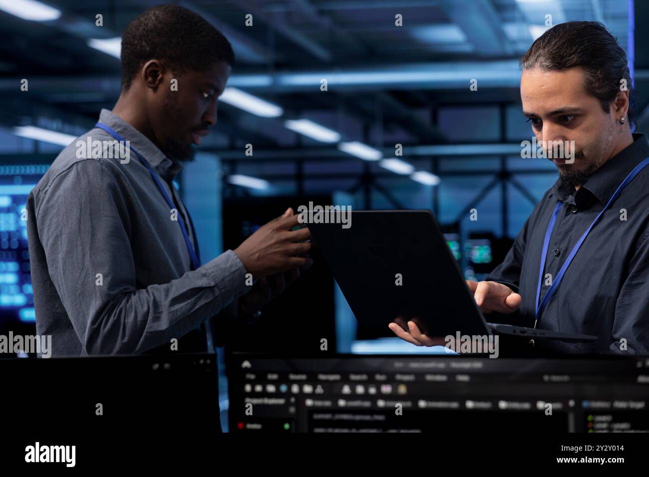 Programmers in data center running system diagnostic tests on laptop to ...