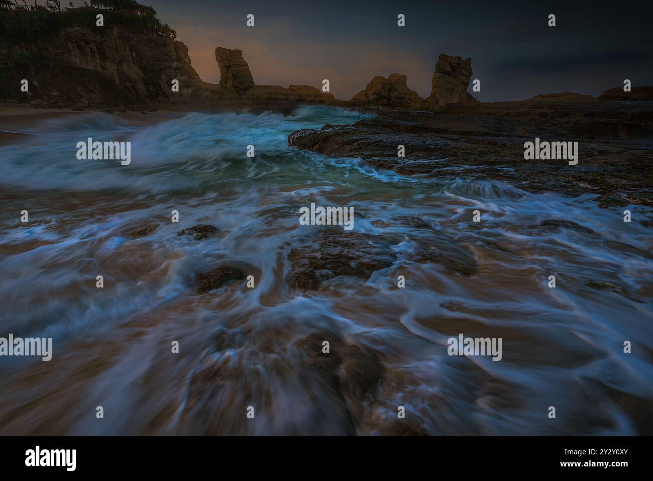 A stunning seascape featuring flowing water over rocky terrain during ...