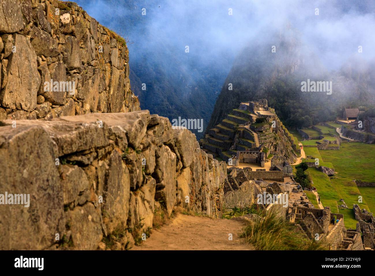 A stunning view of Machu Picchu with ancient stone structures and misty ...