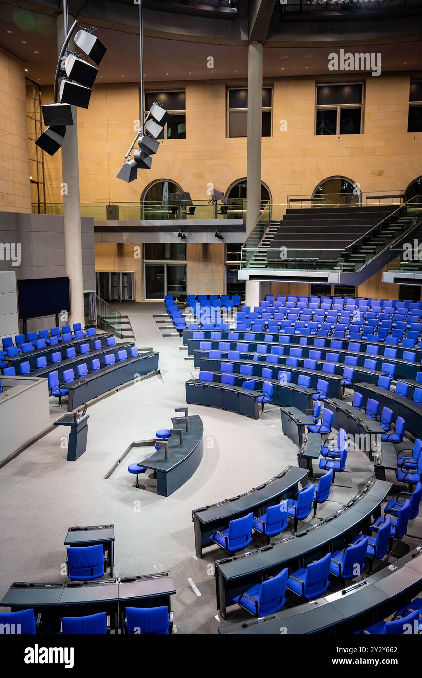 Interior of an empty modern parliamentary chamber with blue seats and ...
