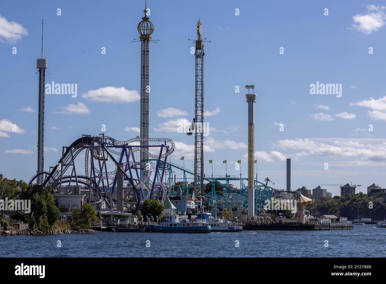 A vibrant amusement park scene featuring various rides including roller ...