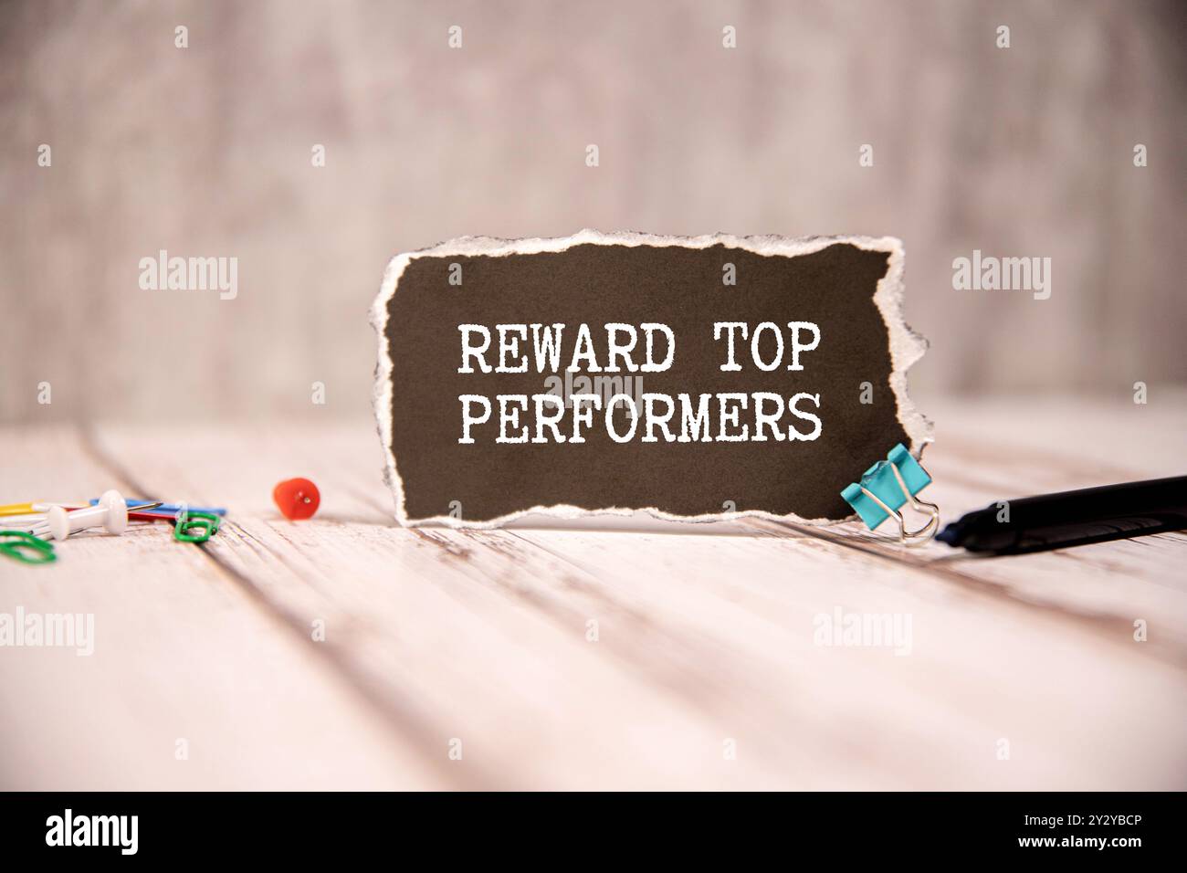 Reward top performers text memo written on a white background with ...