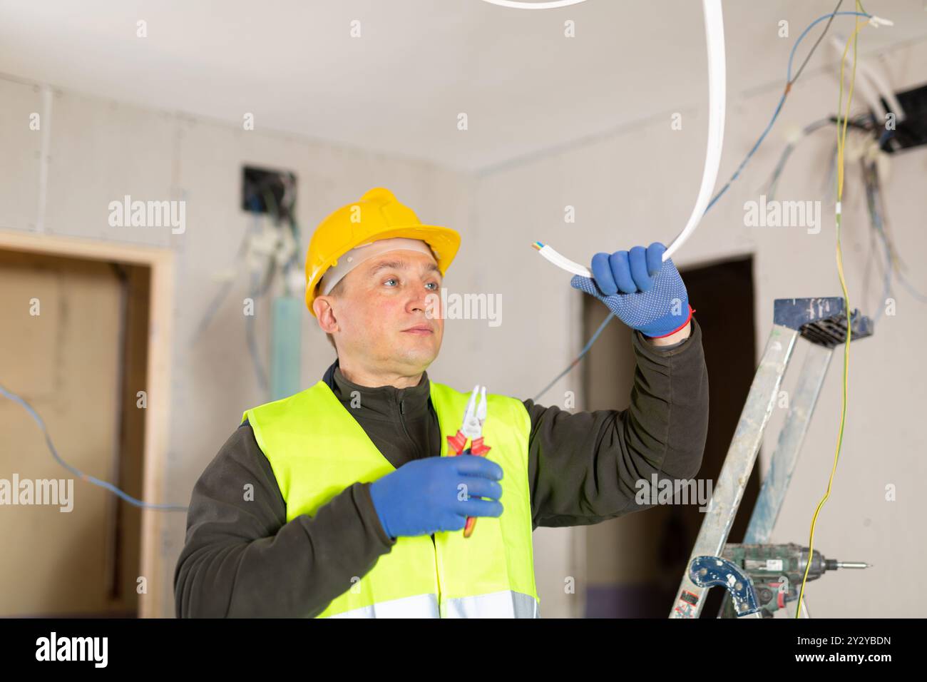 Electrician working with wires in apartment Stock Photo - Alamy