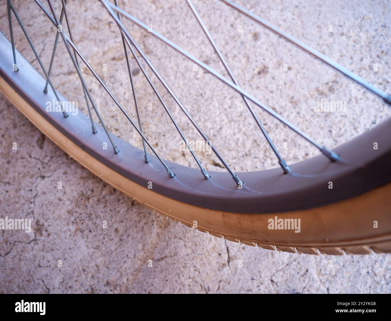 Vintage bicycle wheel with white tire resting on a concrete surface ...
