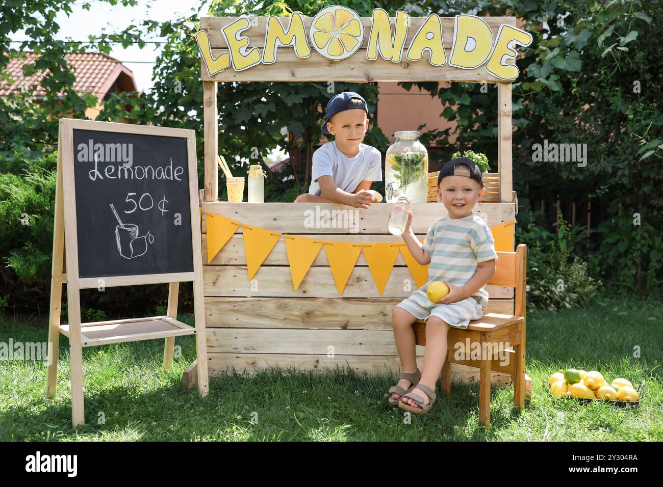 Cute boys near lemonade stand in park Stock Photo - Alamy
