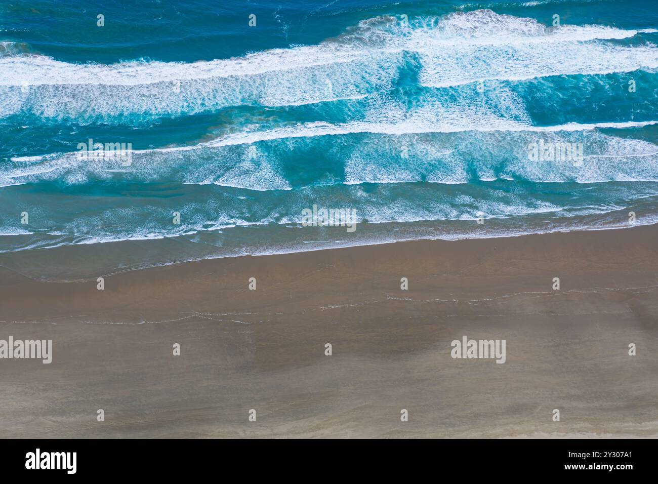 An aerial view of rolling white-capped ocean waves heading towards the ...