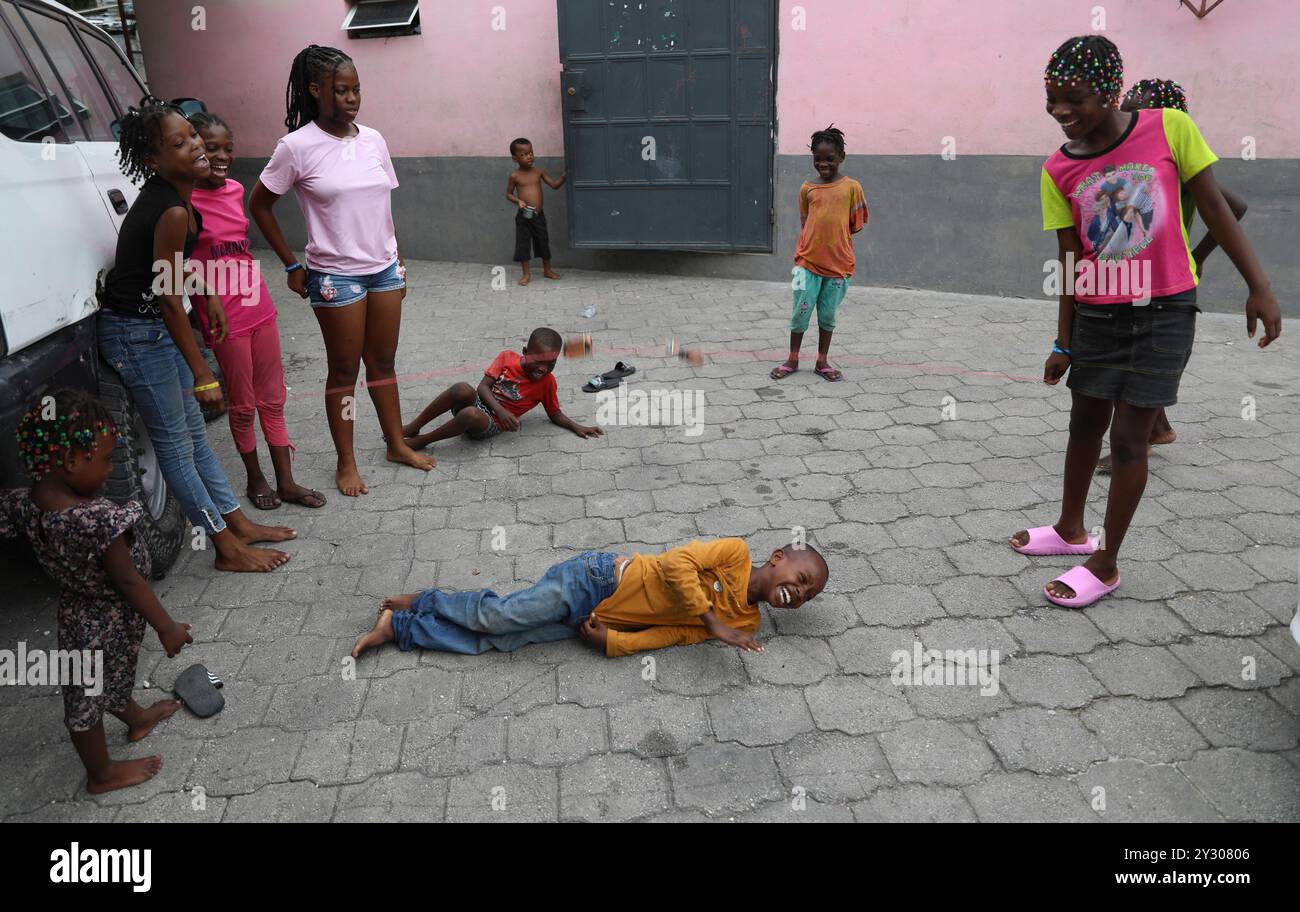 Children laugh while jumping rope at a school that serves as a ...