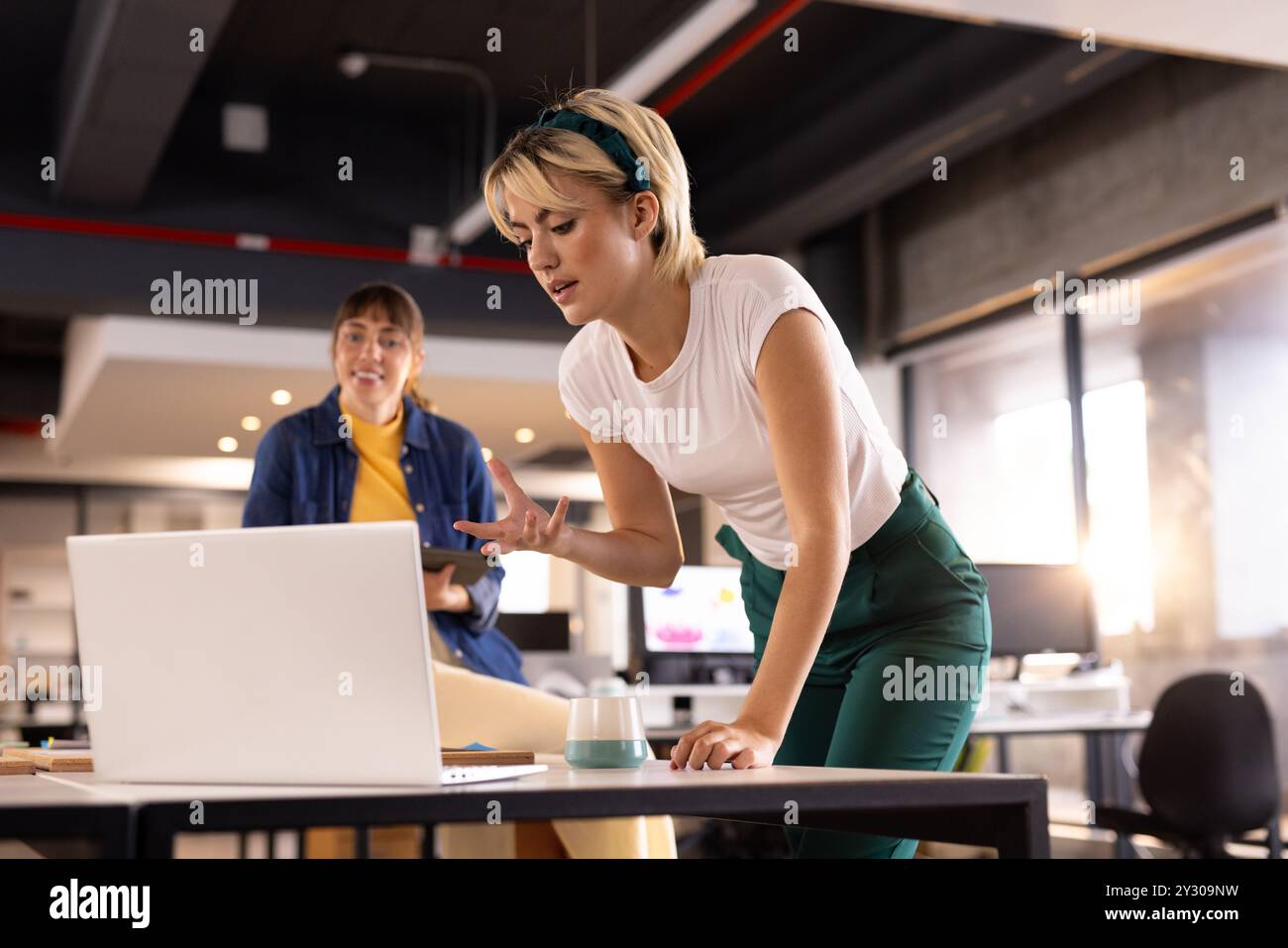 Collaborating on project details, multiracial women in modern office ...