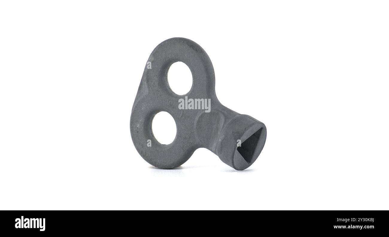 A vintage metal clock key with a two-hole design, isolated on a white ...