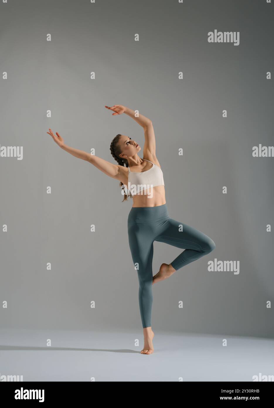 Dancer performing a graceful pose in a minimalist studio setting Stock ...