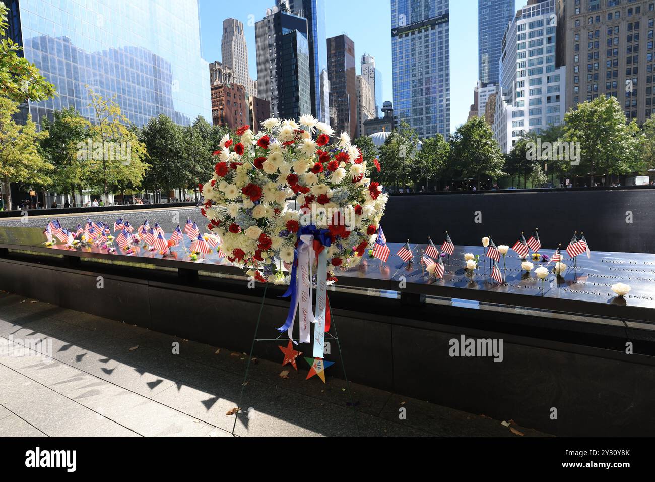 Visitors place flags and take photos at the South Pool, one of two ...