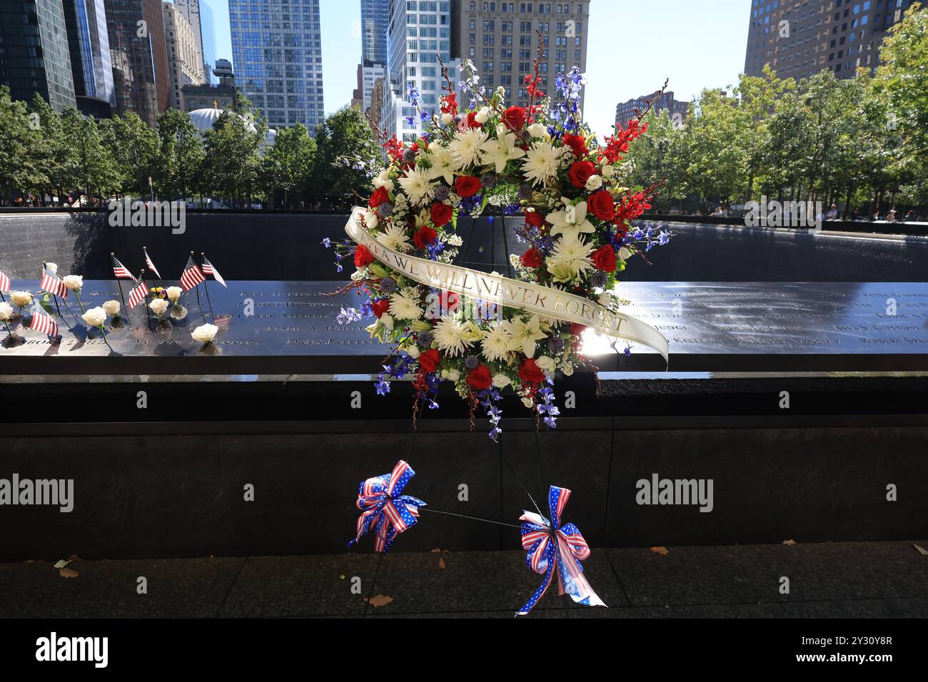Visitors place flags and take photos at the South Pool, one of two ...