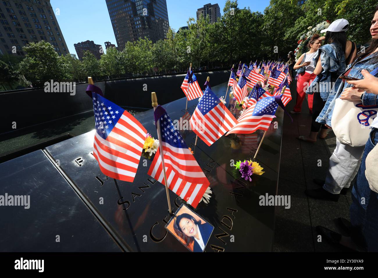 Visitors place flags and take photos at the South Pool, one of two ...