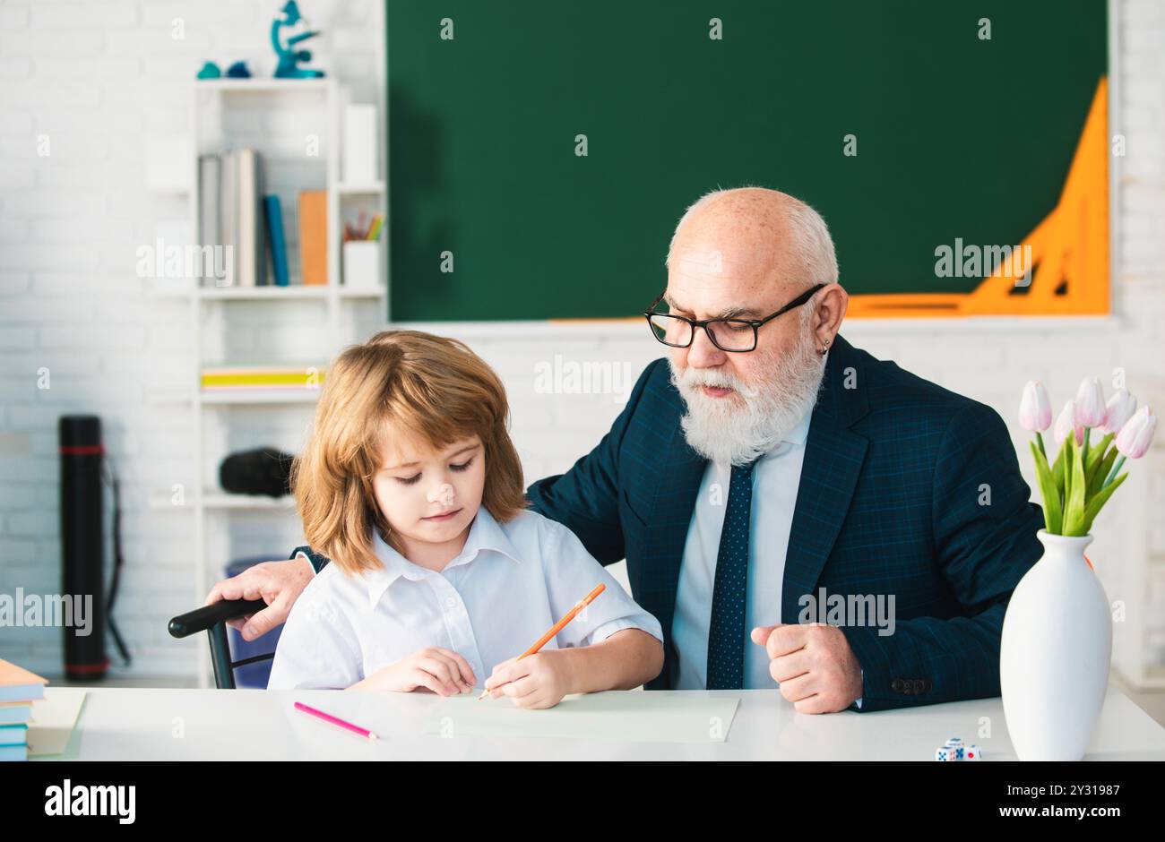 Old professor or senior teacher teaching little school boy. Educational ...