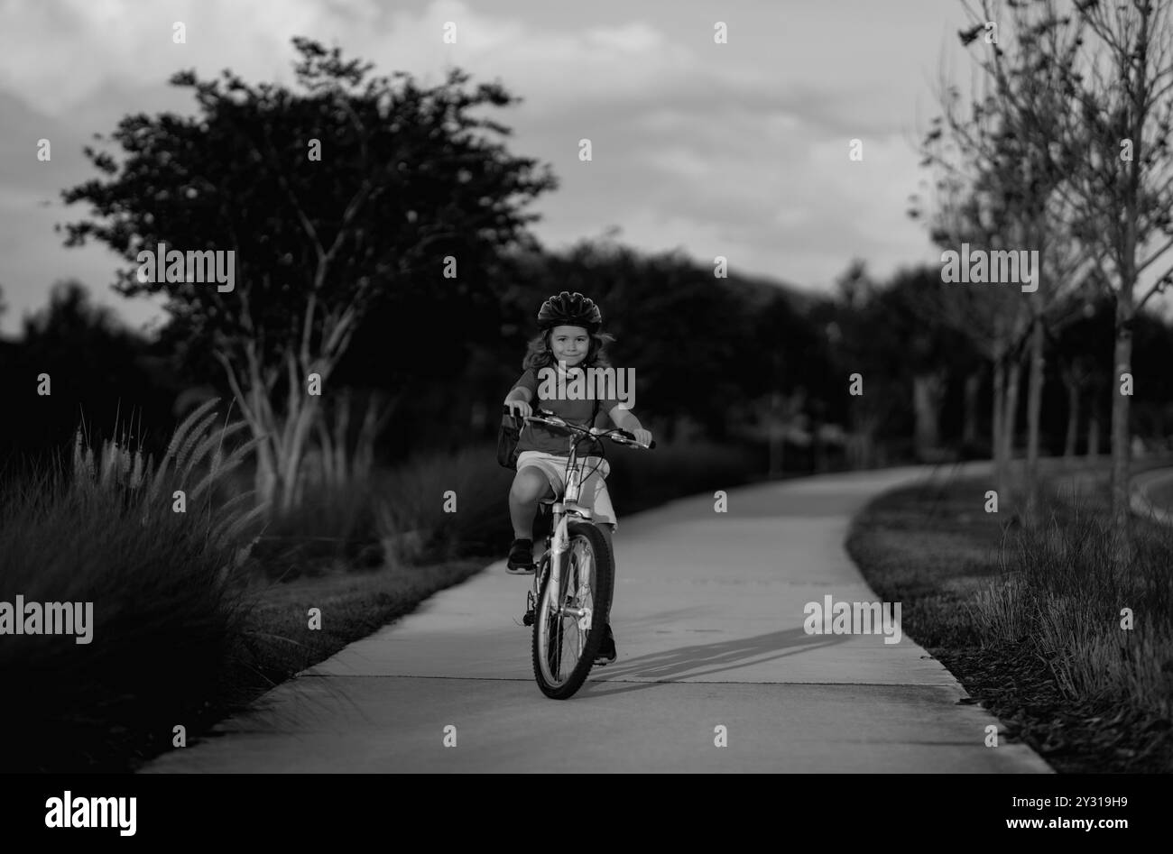 Little kid boy riding a bike in summer park. Child drive a bike on a ...