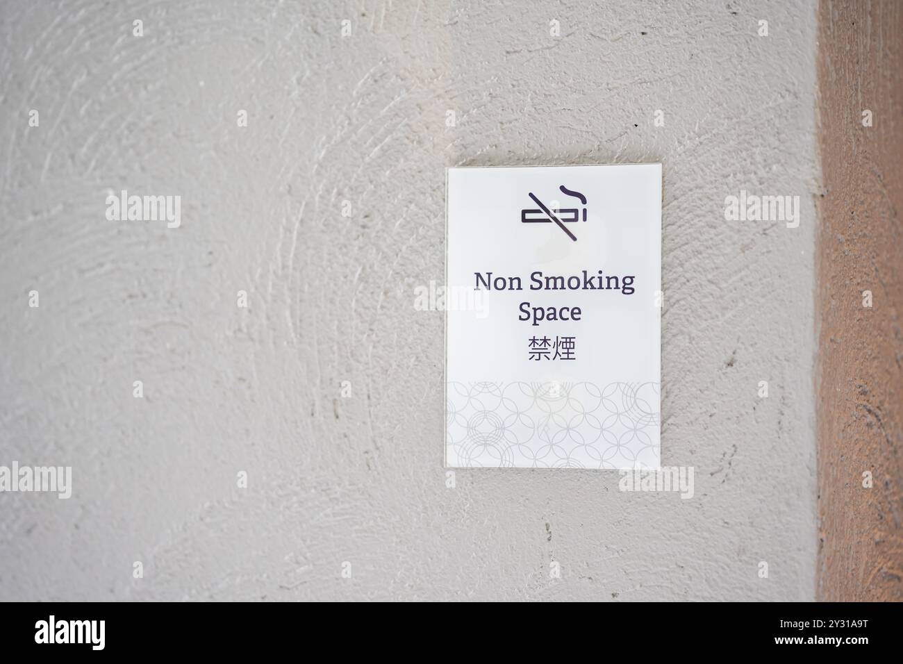 Square white paper no smoking sign on a wall in public place. No ...