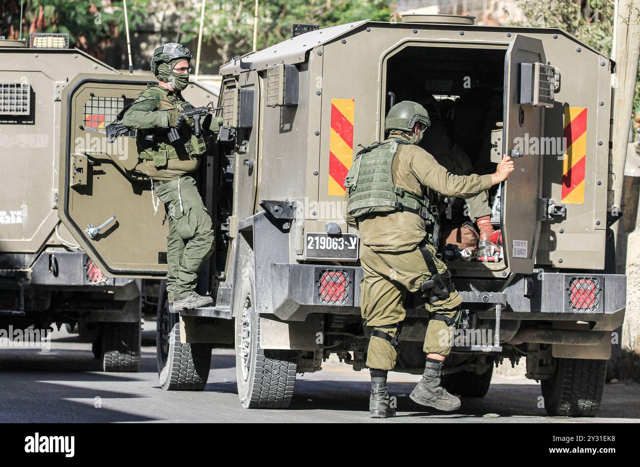 Israeli soldiers board their vehicles after raiding a Palestinian home ...