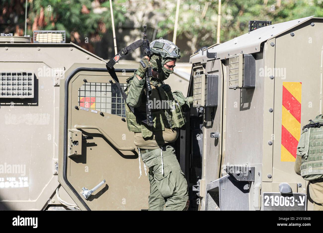 An Israeli soldier boards his vehicle during raiding a Palestinian home ...