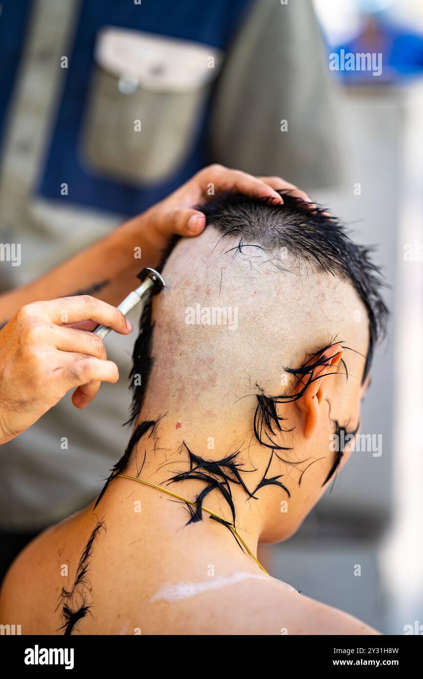 Boy be removed hair to become a nun during a Buddhist ordination. Close ...