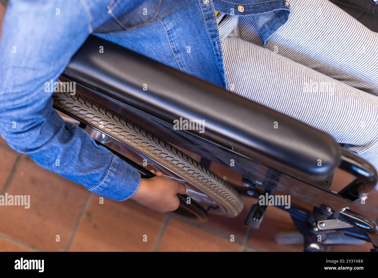 Using wheelchair, african american girl moving forward Stock Photo - Alamy